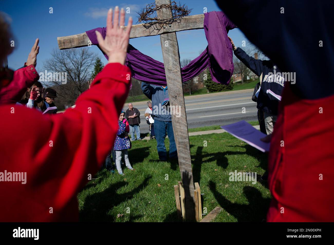 Congregants raise their hands in prayer as they face a cross during the ...