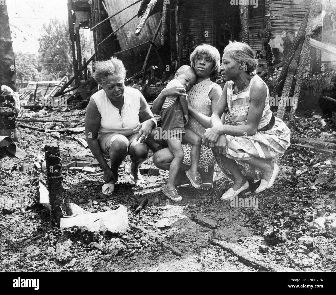 Three women and a child visit the charred ruins of what used to be ...