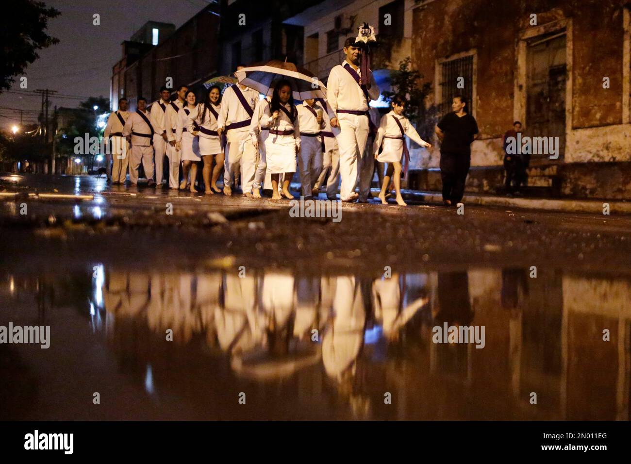 A group of "estacioneros" walk barefoot in the rain during their ...