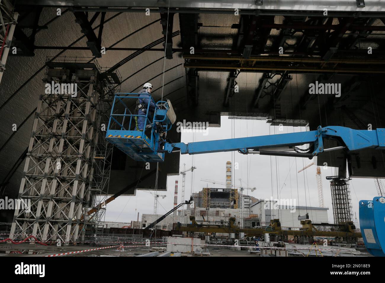 Construction workers assist in the assembly of a gigantic steel-arch to ...