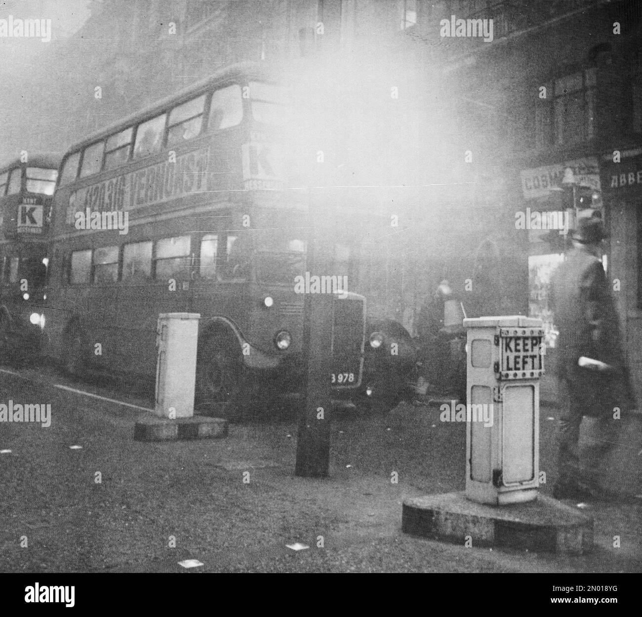 Two of London's double decker buses move slowly through fog shrouded ...