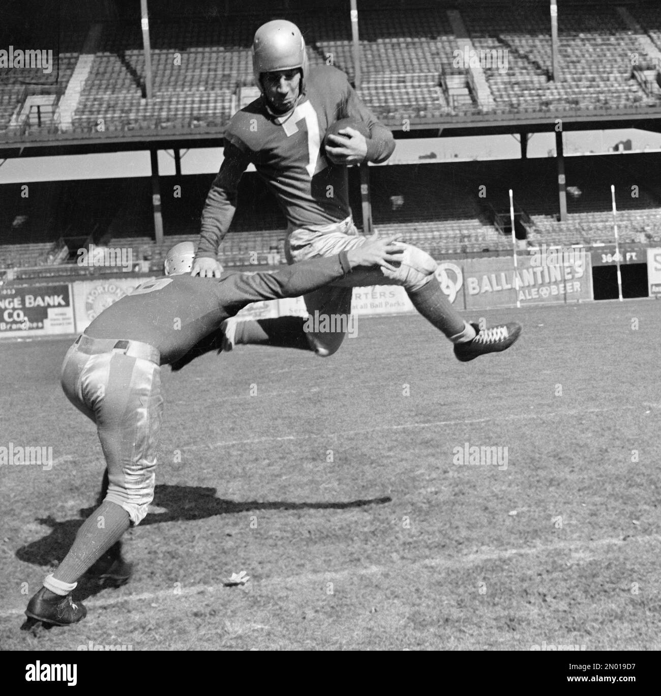 Clarence "Ace" Parker of the Brooklyn Dodgers football team stiff-arms ...
