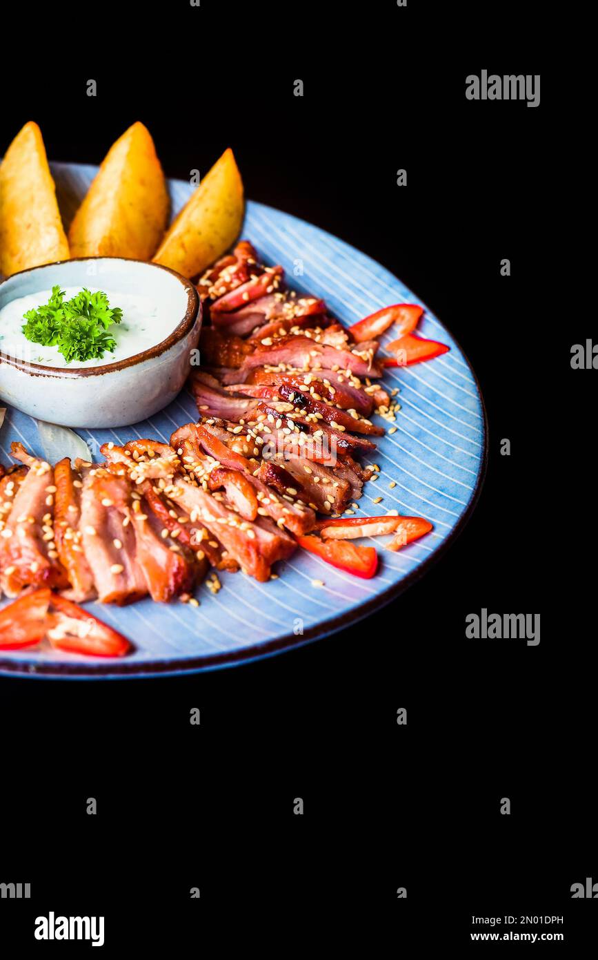 Goose fillet fried with garlic served with potato wedges and kim chi on ...