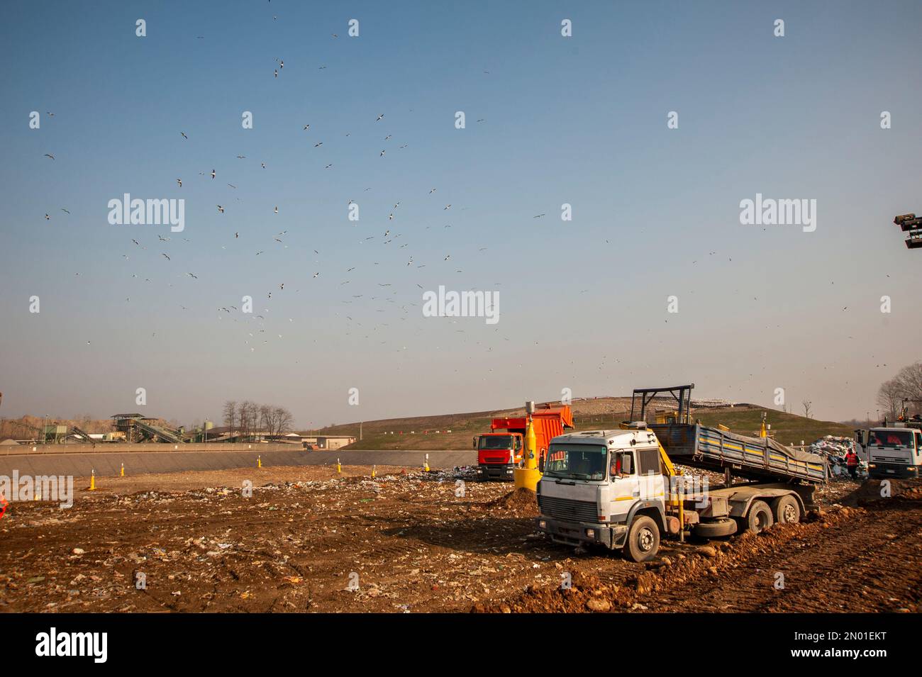 Municipal waste landfill. Workers with trucks and bulldozers at work in ...