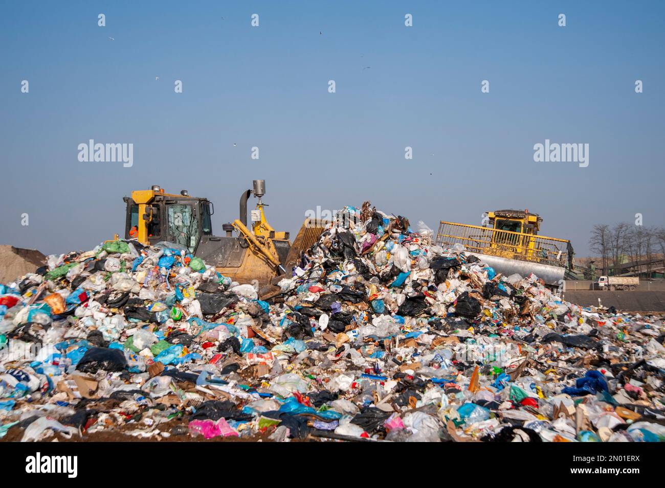 Municipal waste landfill. Workers with trucks and bulldozers at work in ...