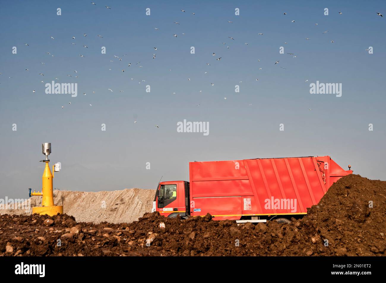 Municipal waste landfill. Workers with trucks and bulldozers at work in ...