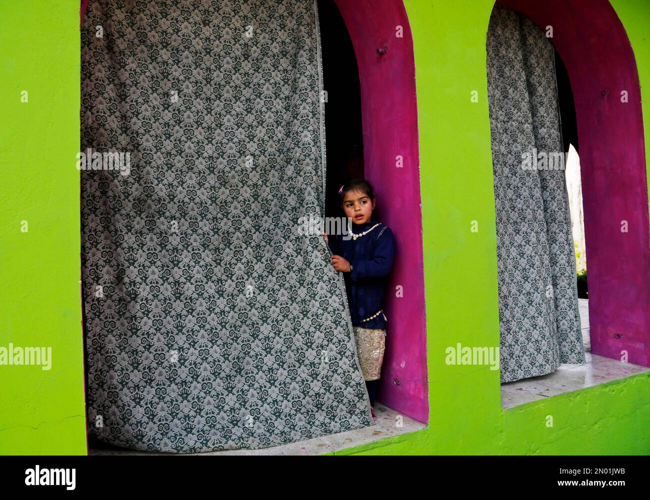 A Kashmiri Shiite Muslim boy waits as his parents offer prayers at the ...