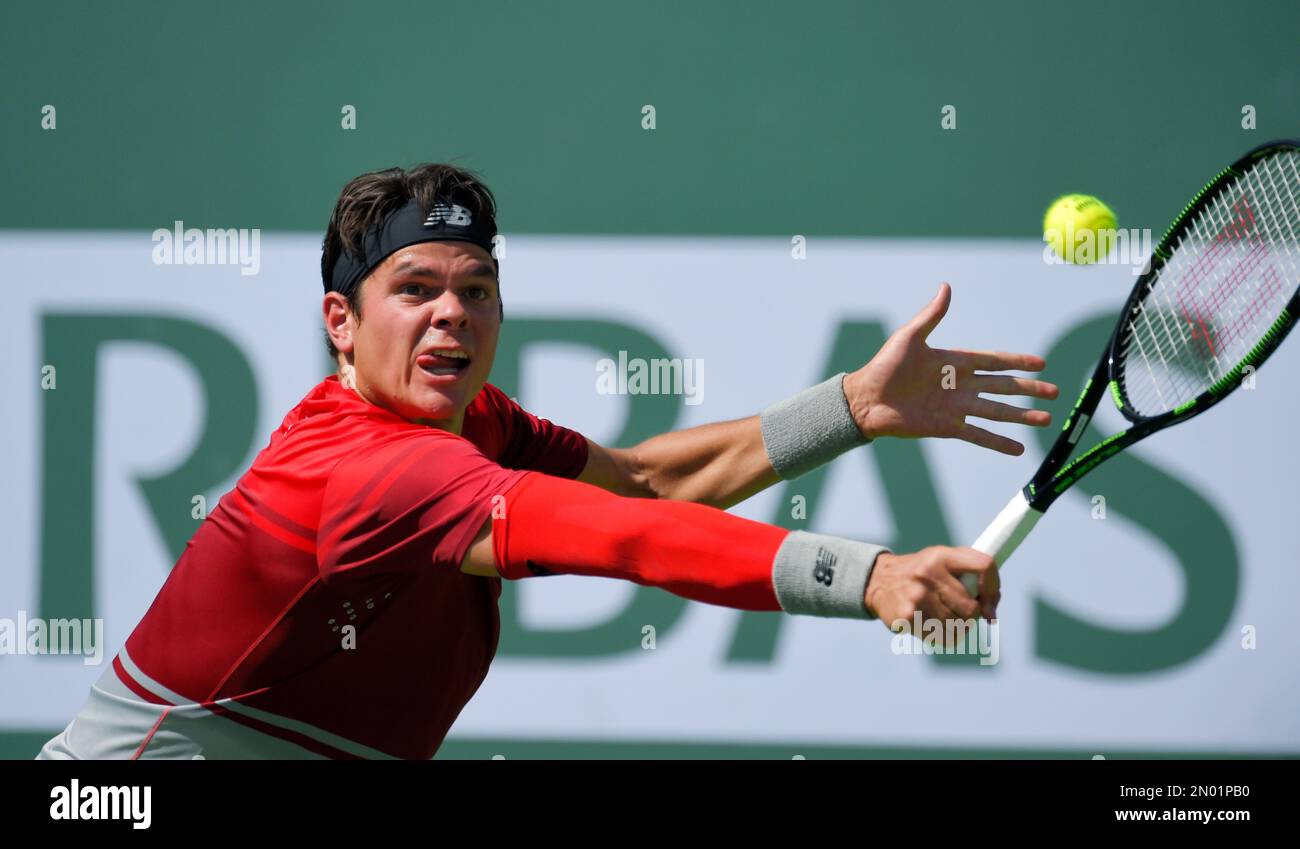 Milos Raonic, of Canada, returns to Novak Djokovic, of Serbia, in a ...