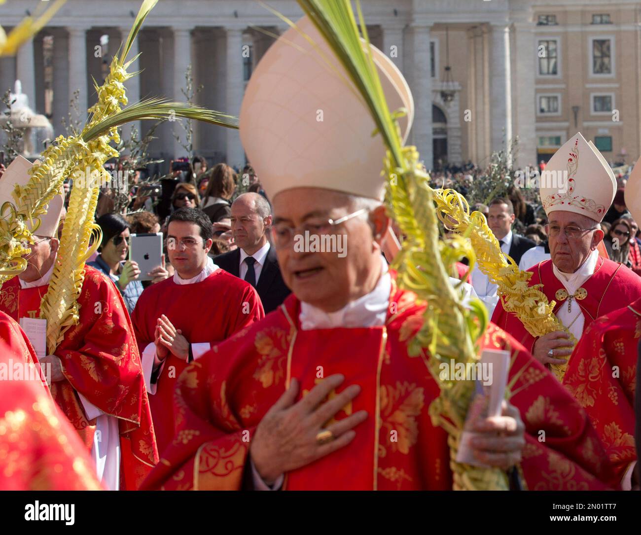 Pope Francis, right, walks in procession as he celebrates Palm Sunday ...