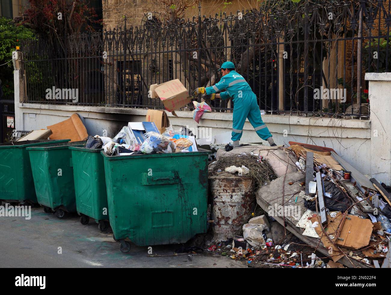 A waste management worker collects garbage in Beirut, Lebanon, Saturday ...