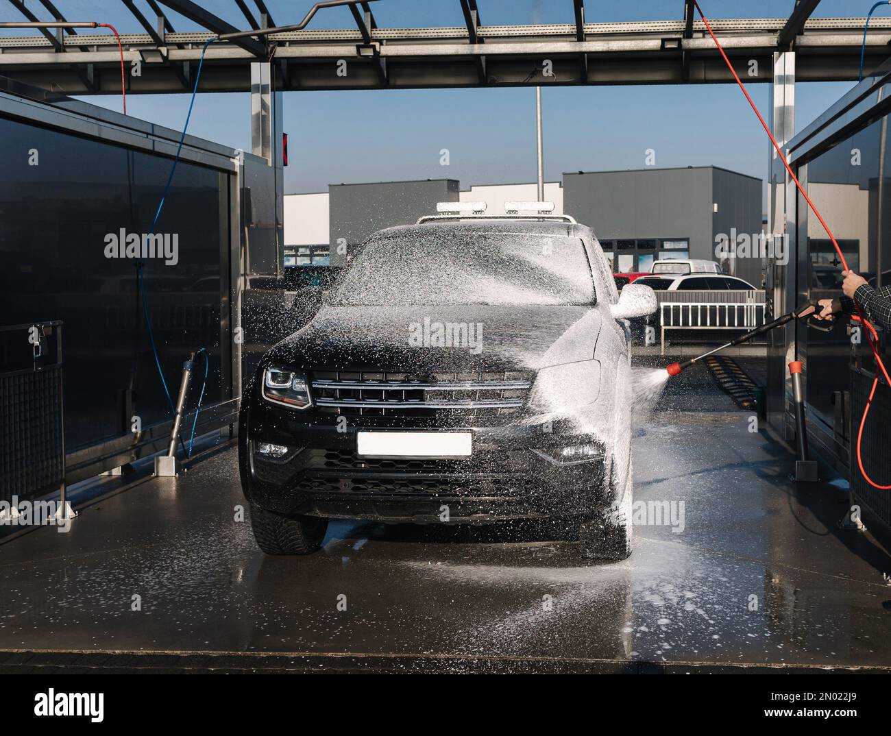 Cleaning car on self service car wash. Man spread soap using jet ...