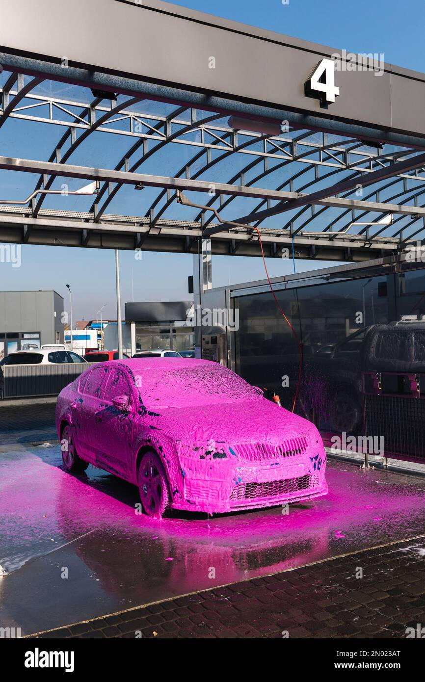 Luxury sport blue car on self servise car washing. Pink foam on auto ...