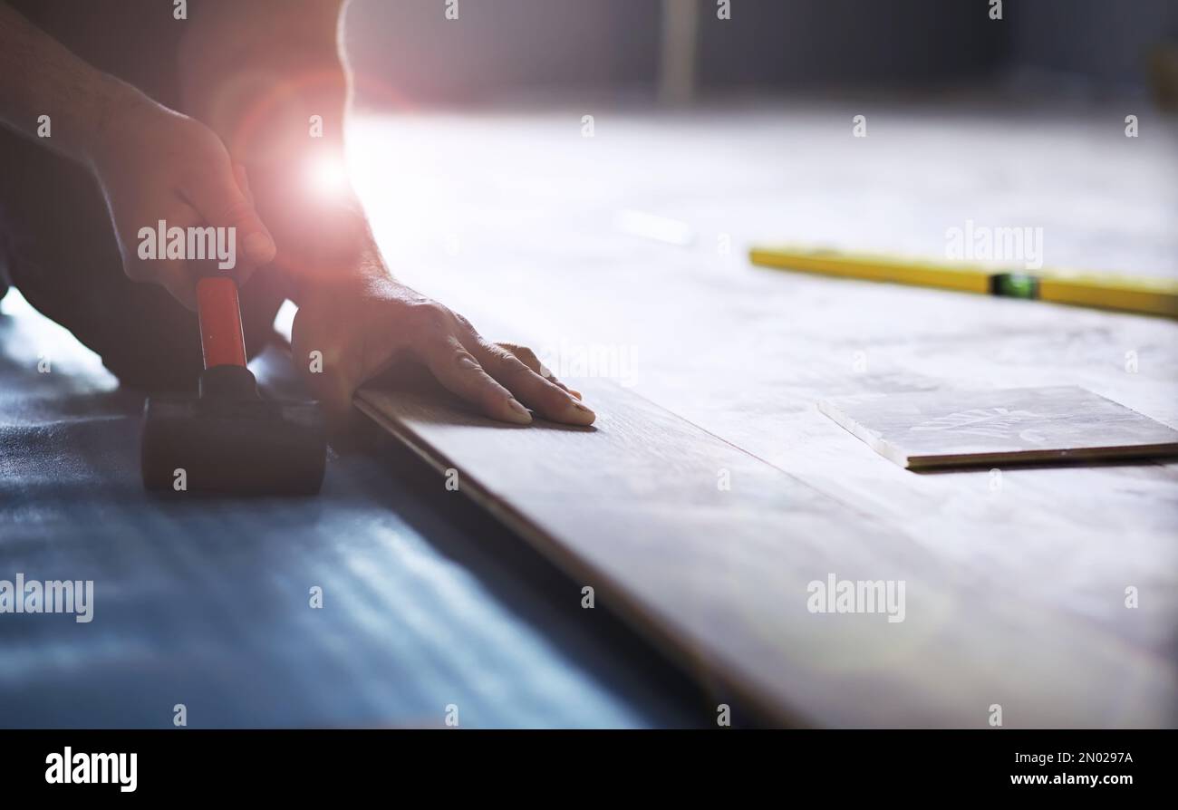 Installing laminated floor, detail on man hands holding wooden tile ...