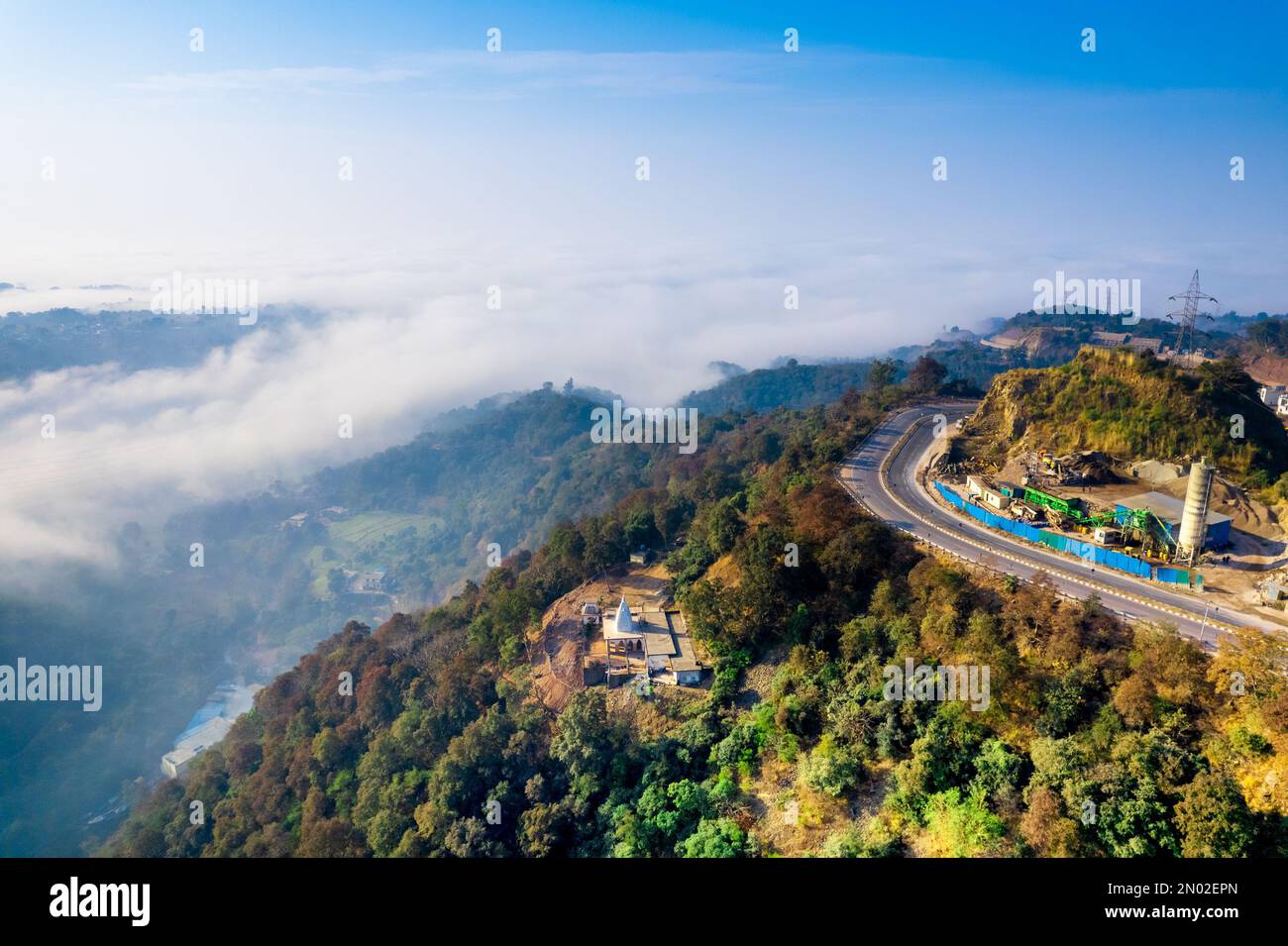 aerial drone pan shot from mountain hill road highway with cars moving on it to valley filled with fog clouds stretching into distance showing Stock Photo Alamy