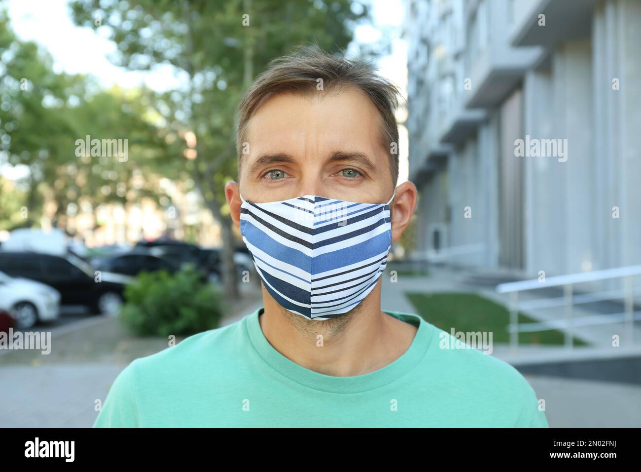Man wearing handmade cloth mask outdoors. Personal protective equipment ...