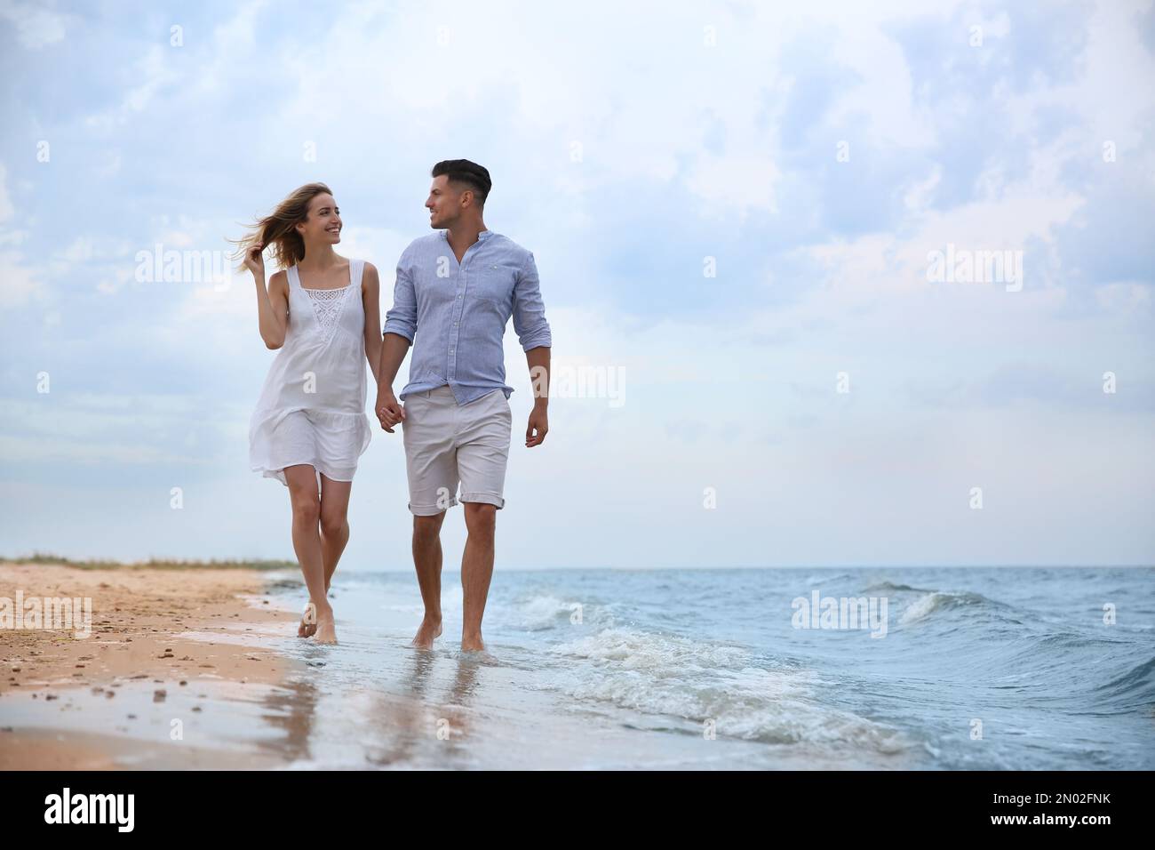 Happy couple having romantic walk on beach. Space for text Stock Photo ...
