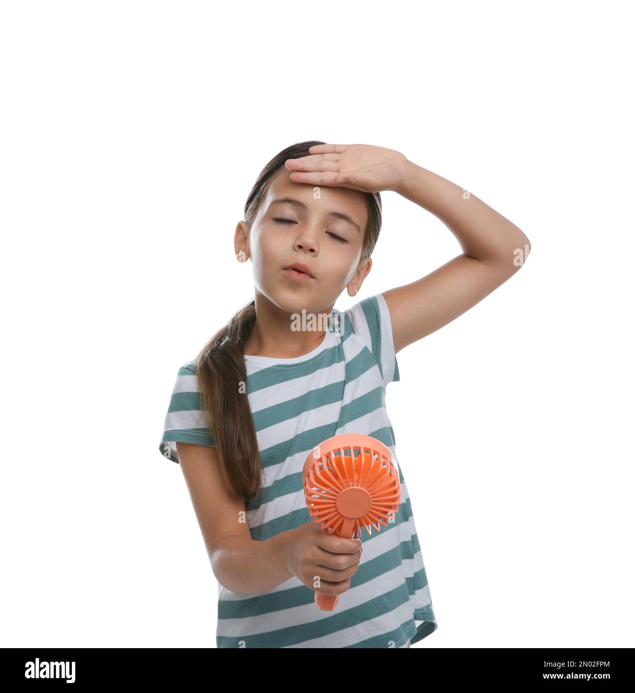 Little girl with portable fan suffering from heat on white background ...