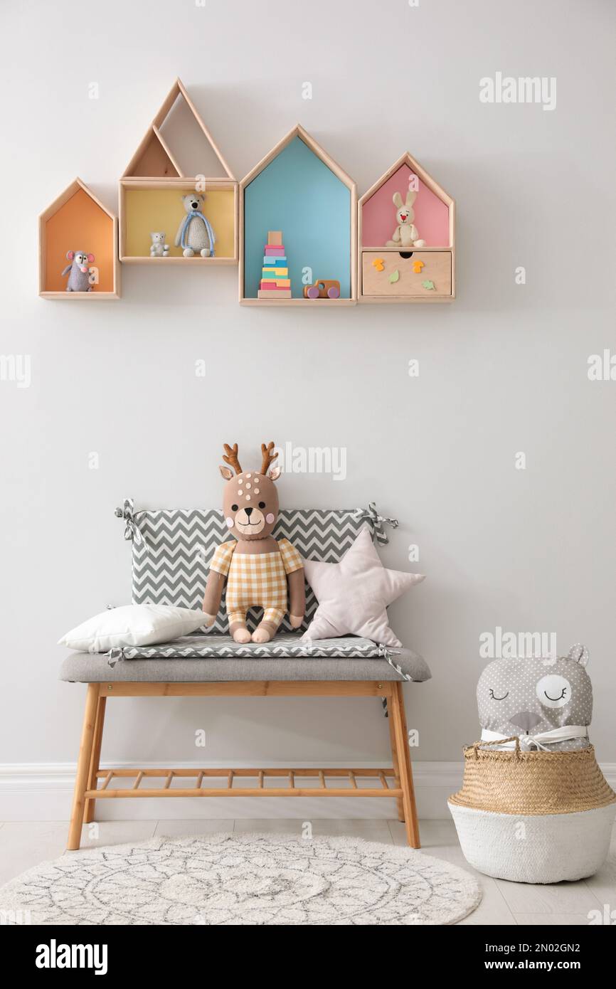 House shaped shelves and bench with toys in children's room. Interior ...