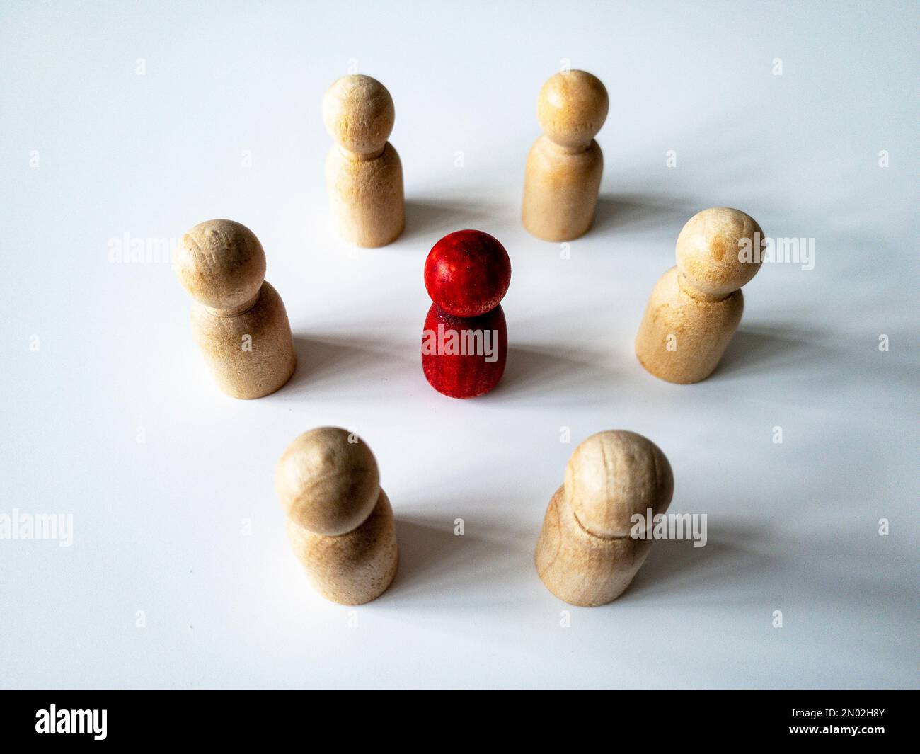 Top side view of red wooden doll figure surrounded by other doll figure ...