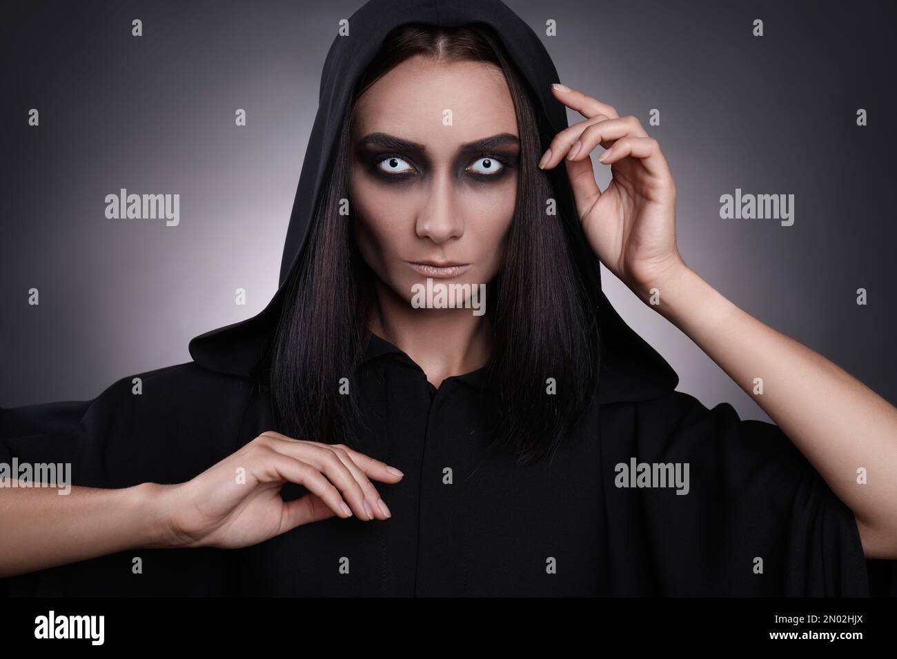 Mysterious witch with spooky eyes on dark background Stock Photo - Alamy