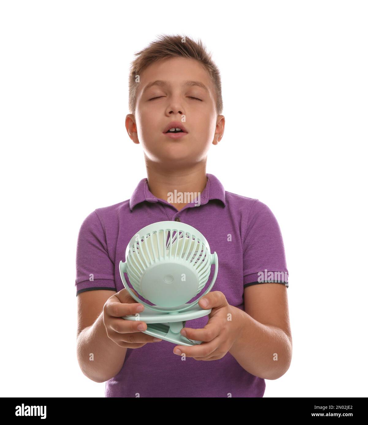 Little boy enjoying air flow from portable fan on white background ...