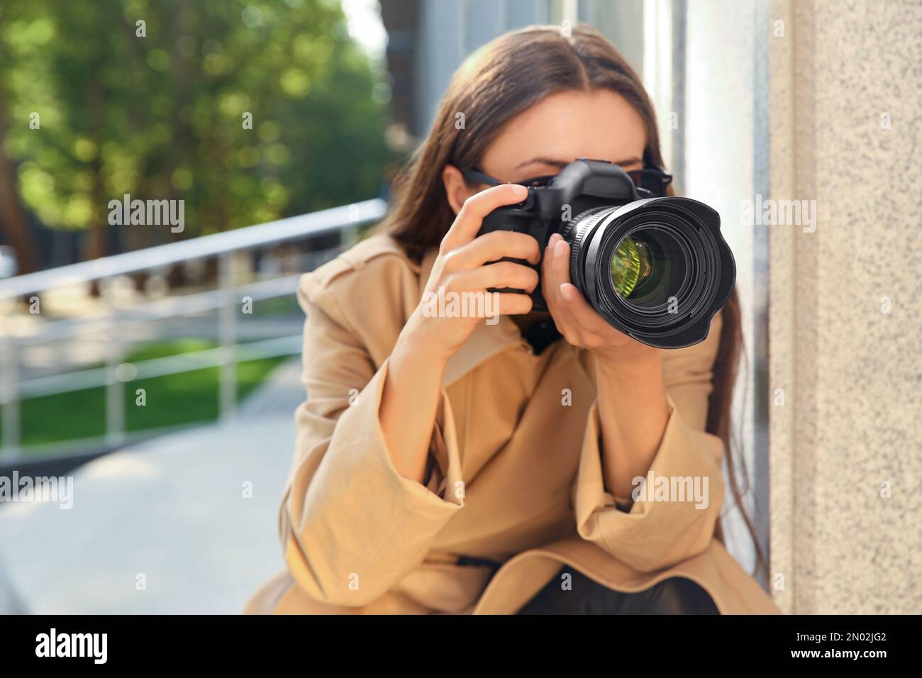 Private detective with camera spying near building on city street Stock ...