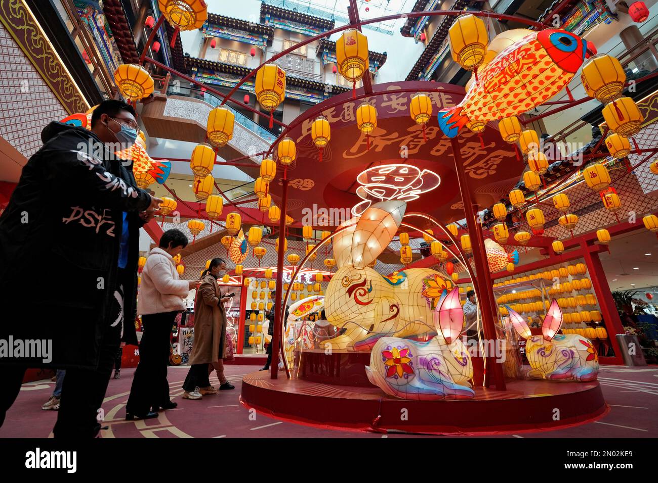 Shoppers look at rabbit-shaped lantern decorations on display inside a ...