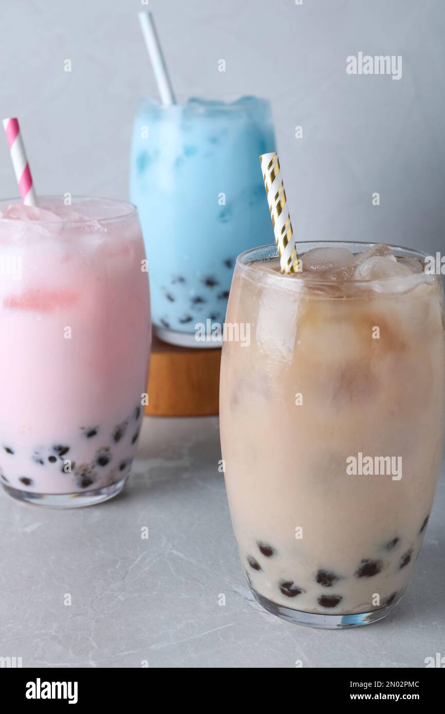 Different milk bubble teas on light grey table Stock Photo - Alamy