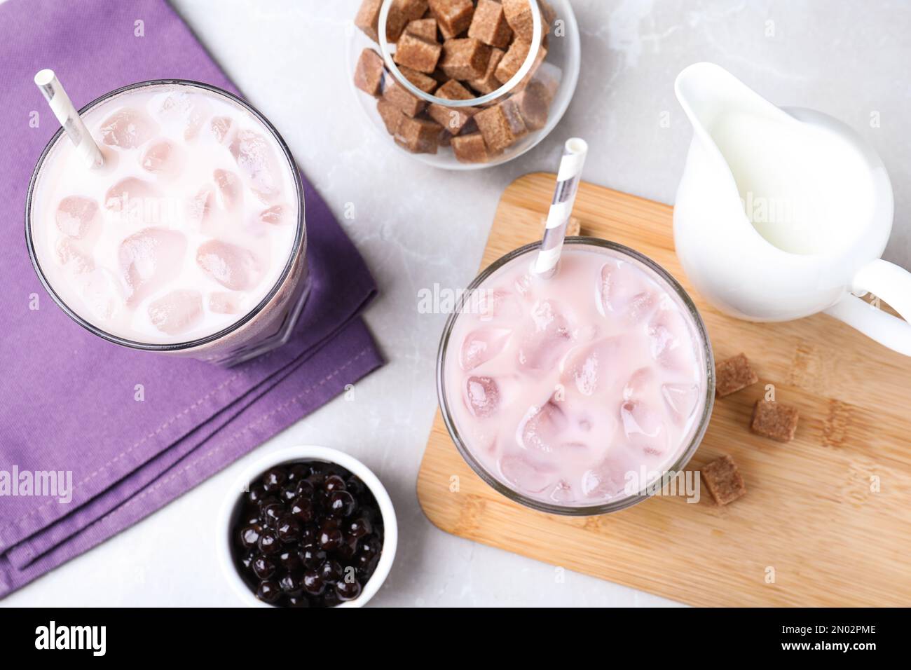 Bubble milk tea and bowl with tapioca balls on light grey marble table ...