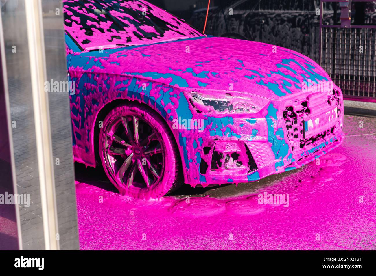 Luxury sport blue car on self servise car washing. Pink foam on auto ...