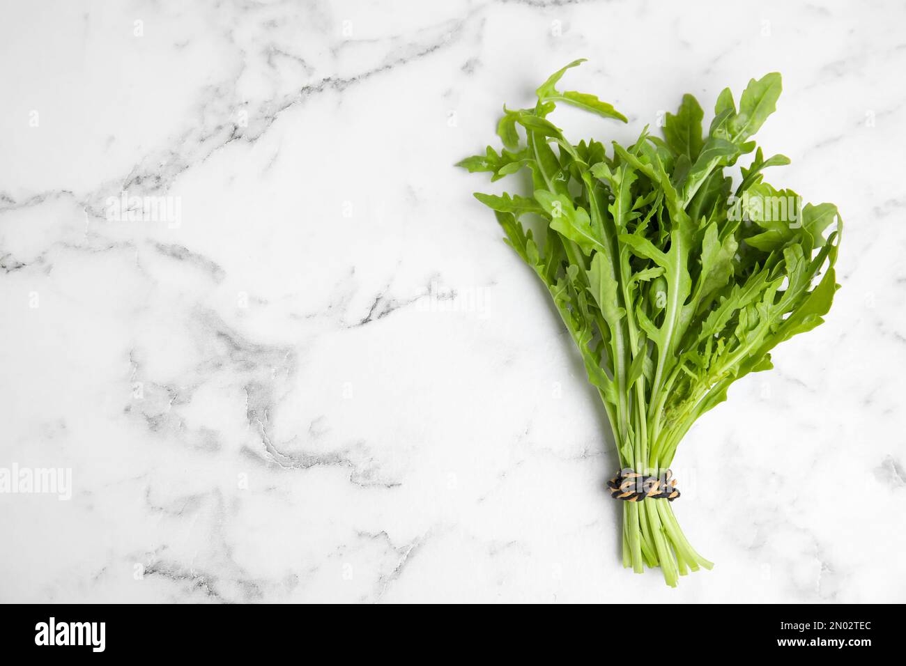 Fresh arugula on white marble table, top view. Space for text Stock ...