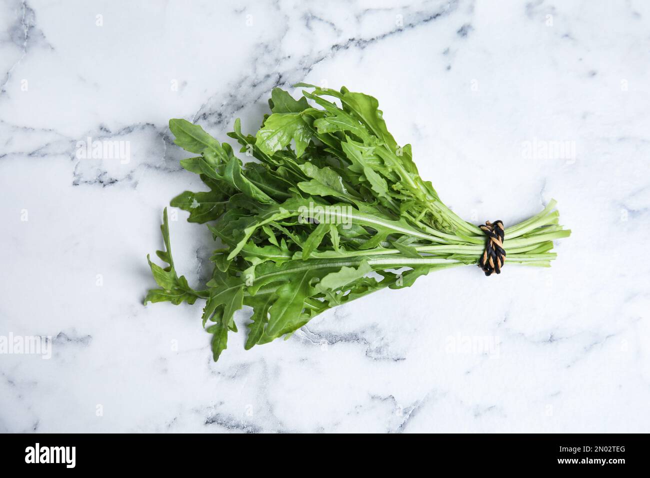 Fresh arugula on white marble table, top view Stock Photo - Alamy