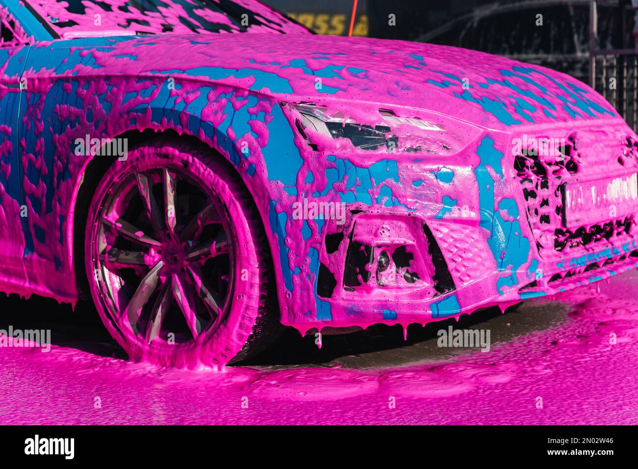 Luxury sport blue car on self servise car washing. Pink foam on auto ...