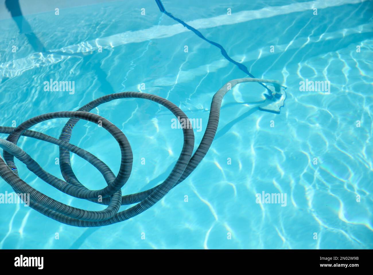 Cleaning outdoor swimming pool with underwater vacuum Stock Photo - Alamy