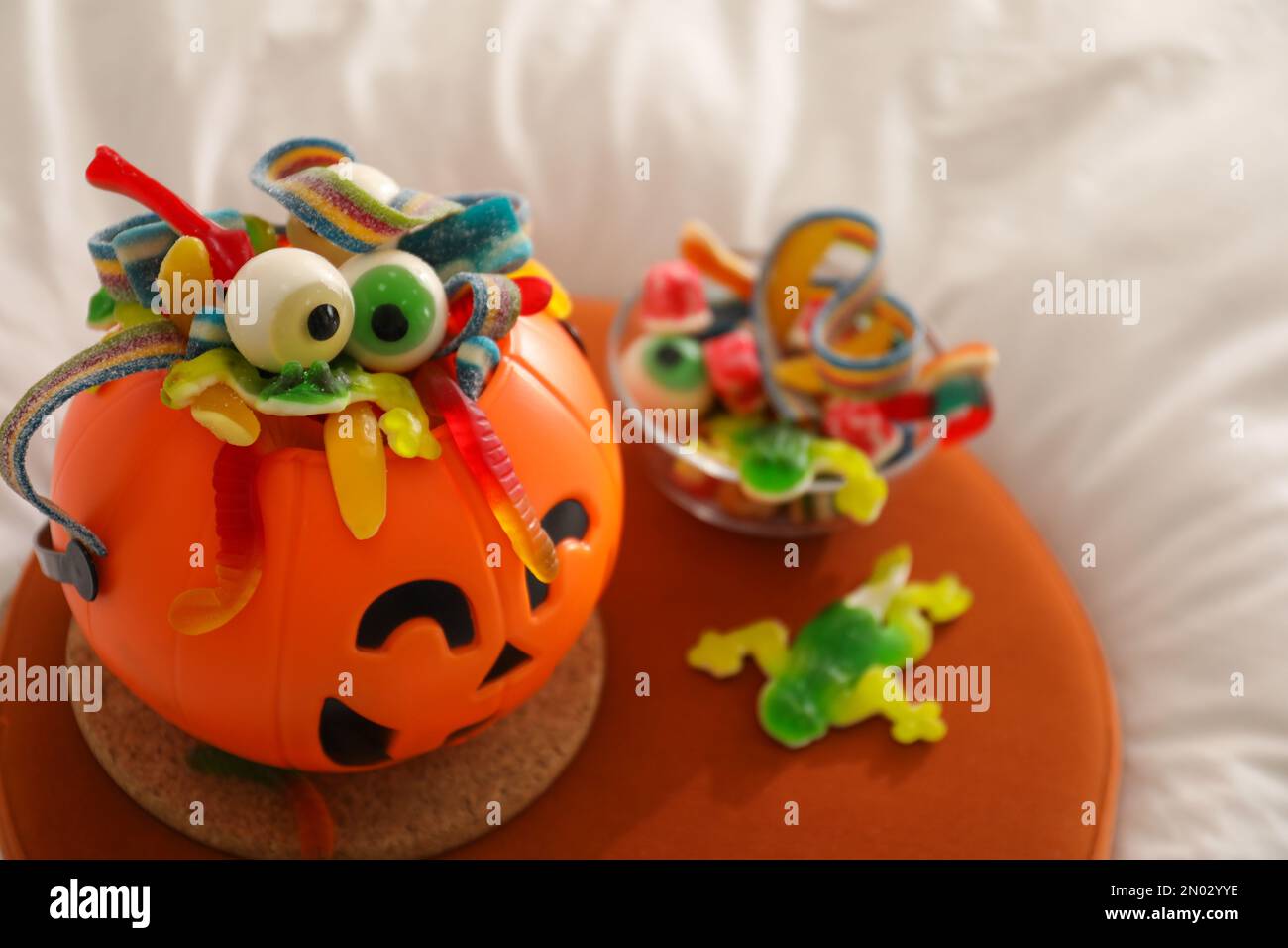 Halloween trick or treat bucket and many different sweets on bed Stock ...
