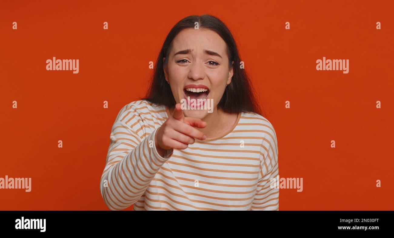 Amused pretty woman pointing finger to camera, laughing out loud ...