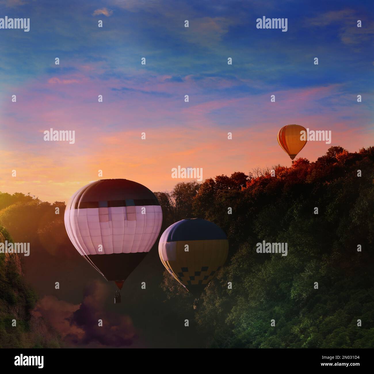 Fantastic dreams. Hot air balloons over forest, beautiful sunset sky ...