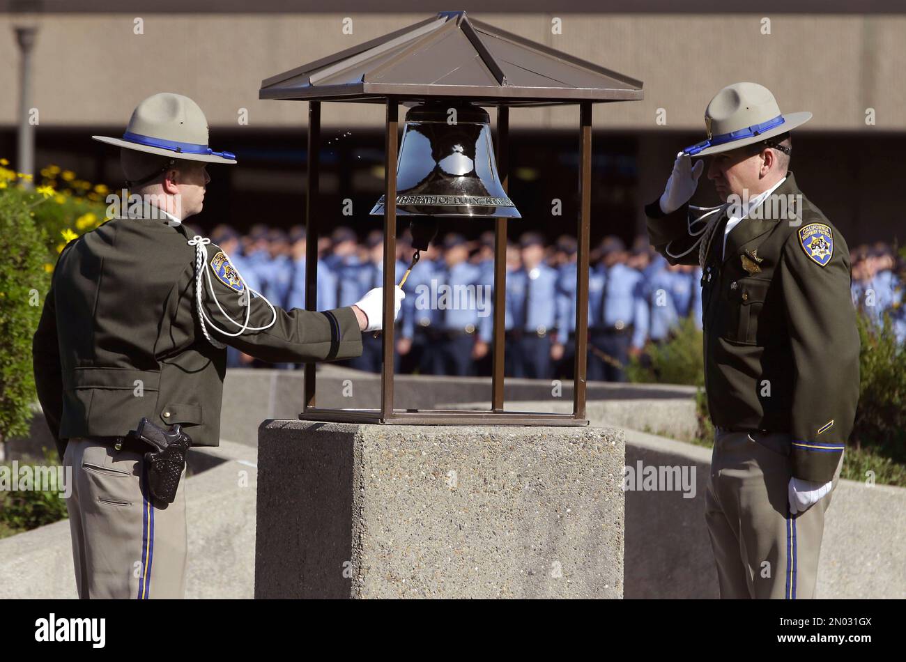California Highway Patrol Officer Brian Samms, left, tolls the memorial ...