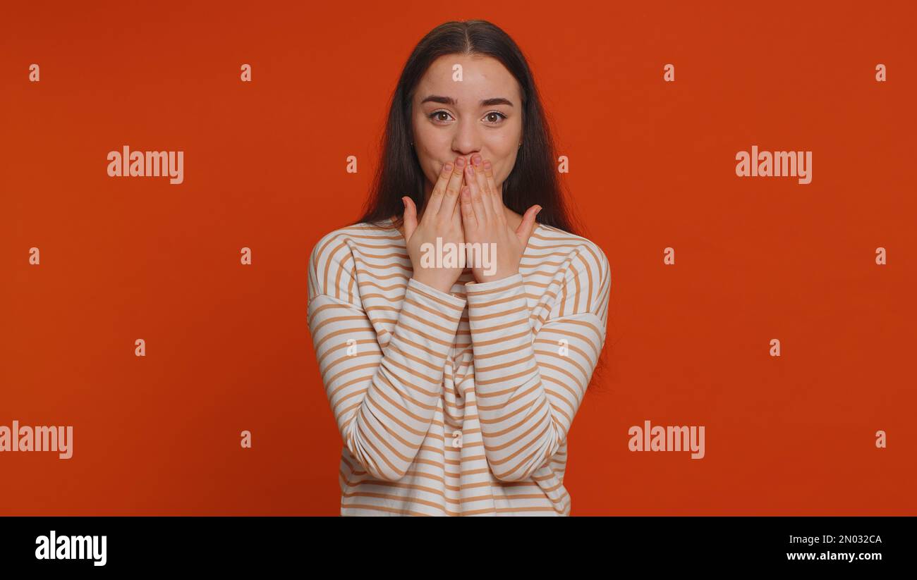 I will not say anyone. Frightened woman closing her mouth with hand ...