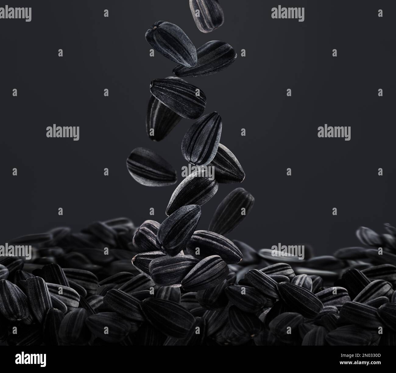 Sunflower seeds falling on dark grey background Stock Photo - Alamy