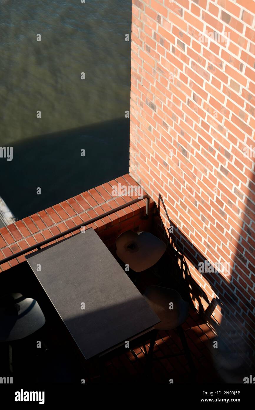 A vertical top view of a black coffee table in a balcony with red brick ...