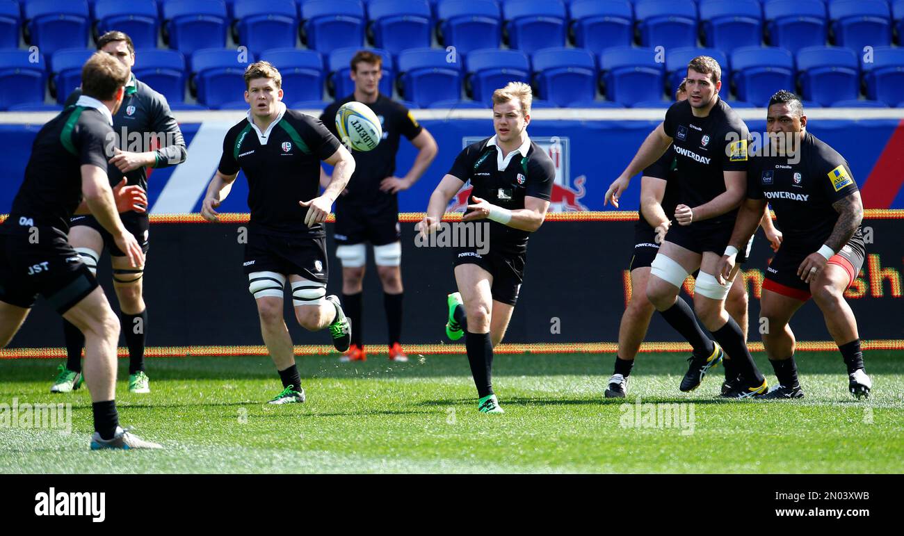 London Irish rugby scrum half Scott Steele, center, passes the ball ...