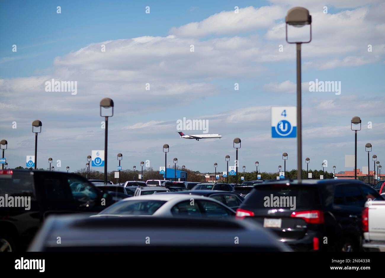 A plane descends over a parking deck to land at Hartsfield-Jackson ...