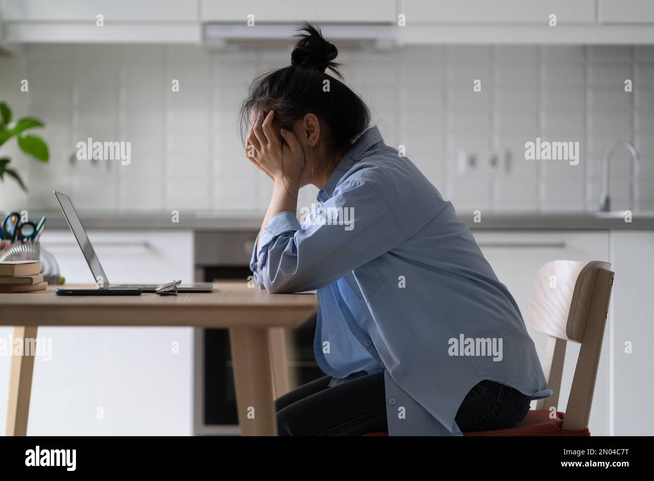 Tired exhausted woman sit at kitchen table with laptop leaning head on ...