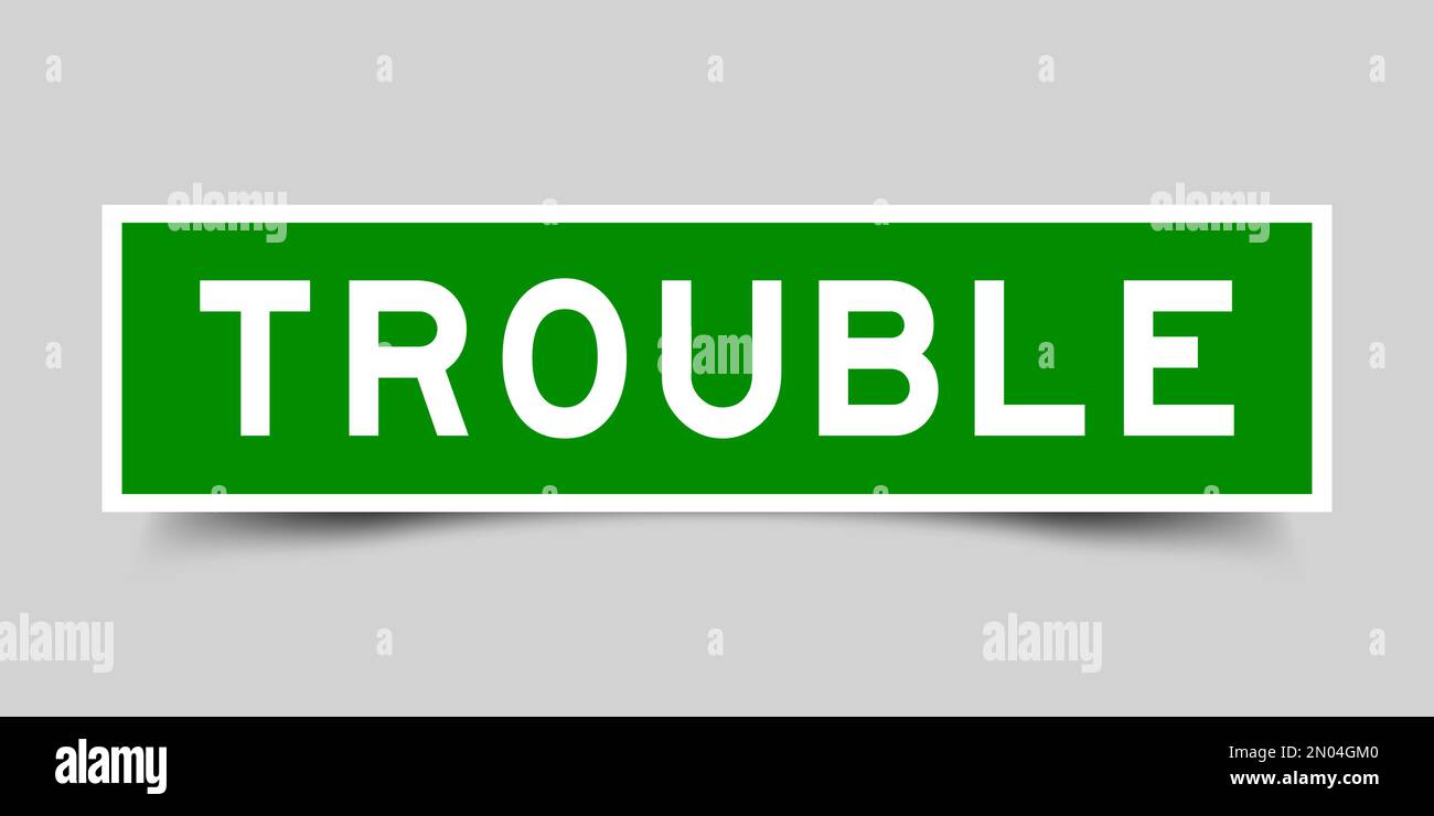 Green color square shape sticker label with word trouble on gray ...