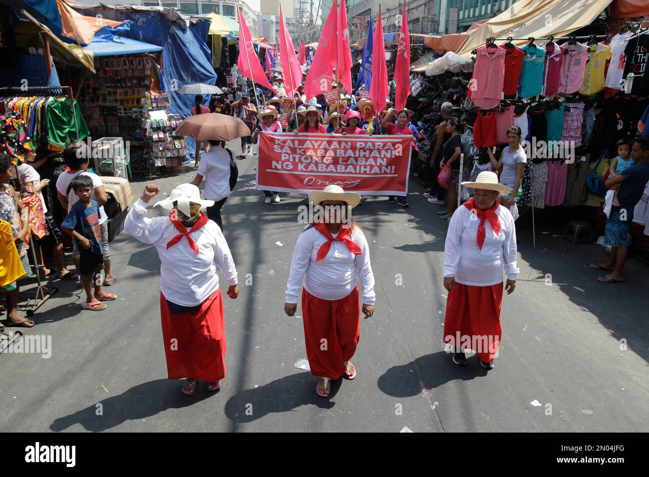 Filipino women activists dressed in costumes march along a street in ...