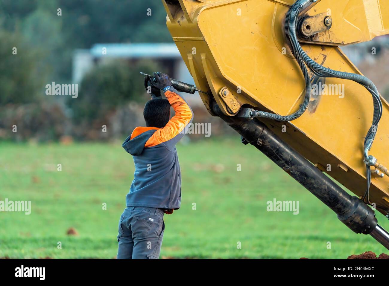 Excavator maintenance and repair operator doing repairs and maintenance ...