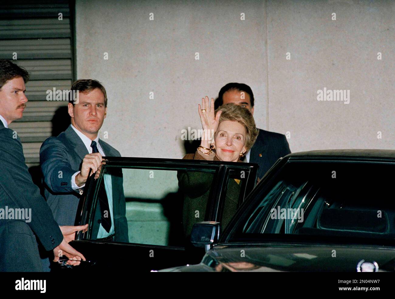 First lady Nacy Reagan waves goodbye as she enters her car after ...