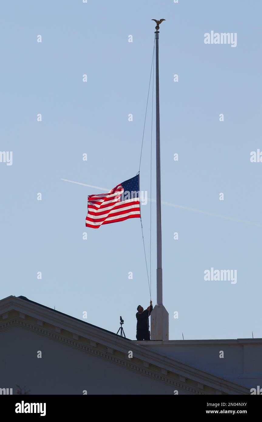 A worker lowers the U.S. flag above the White House in Washington ...