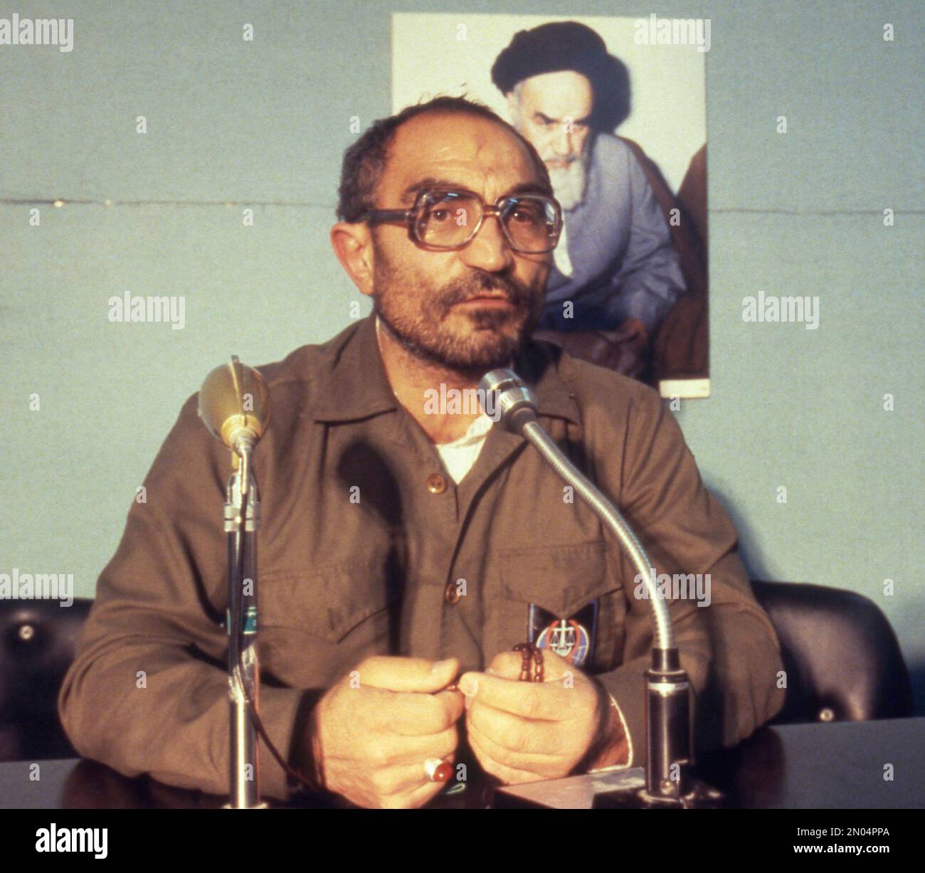 Sitting in front of a portrait depicting Iran's leader, Ayatollah ...